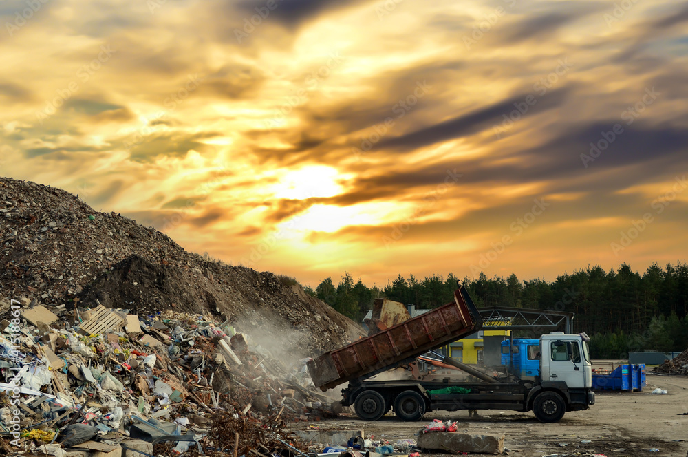 Garbage truck unloads construction waste from container at the landfill ...