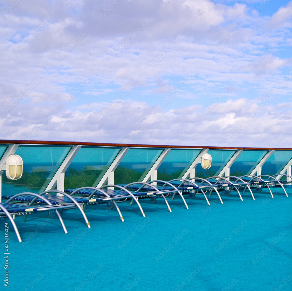 Outdoor pool deck with sun loungers and deck chairs on modern ...