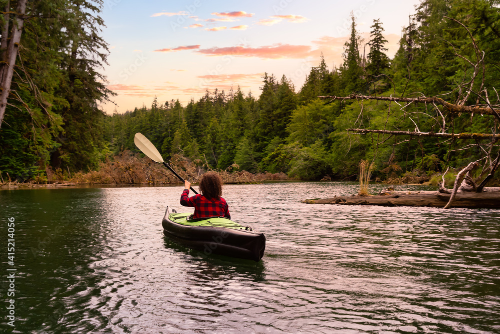 Girl kayaking in a river that connects to Pacific Ocean surrounded by ...