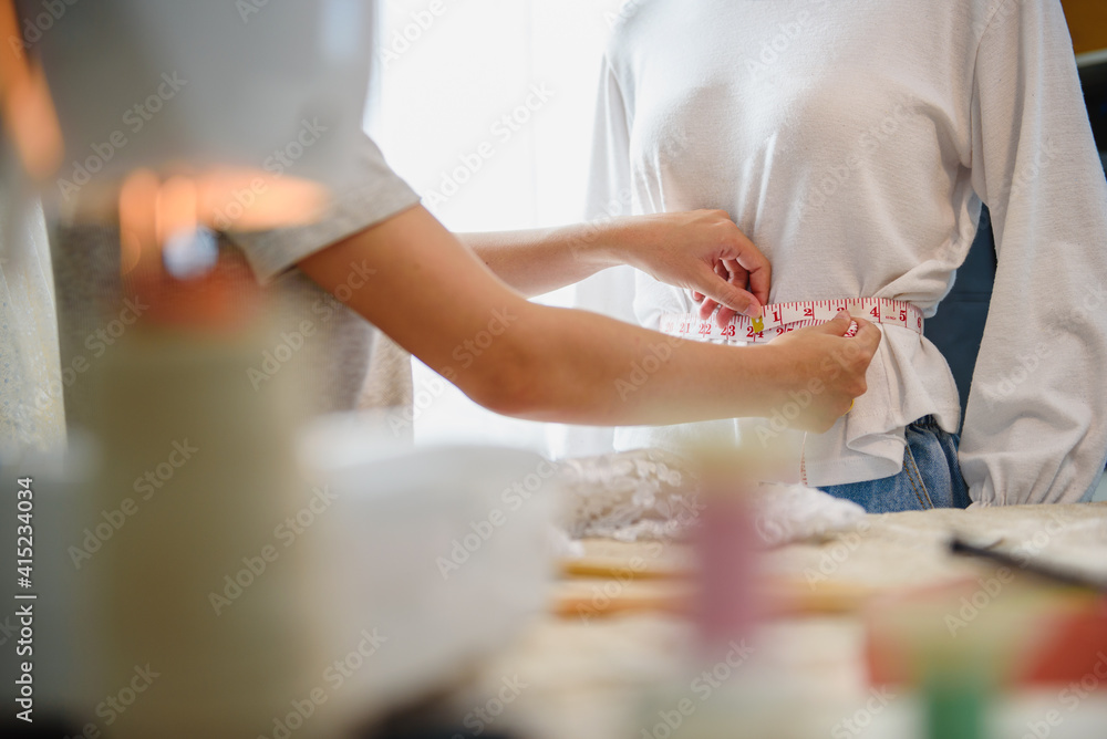 Tailor or Designer woman's taking measurements the customer body for ...