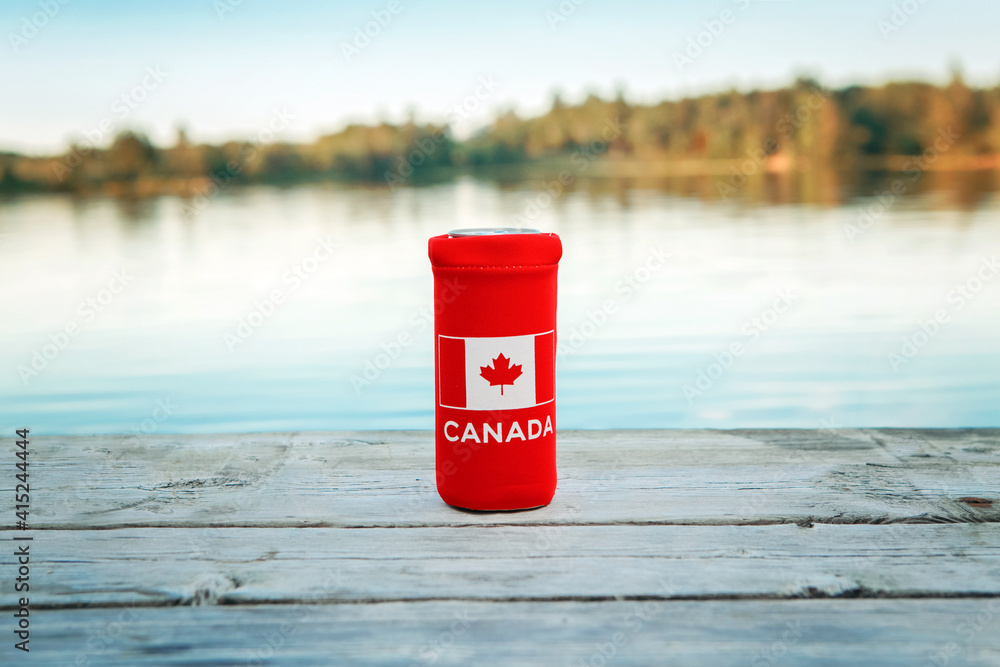Can of beer in red cozy beer can cooler with Canadian flag standing on ...