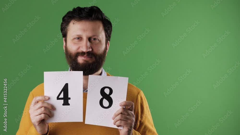 Man holding number 48 sign. Cheerful white bearded good-looking man in ...