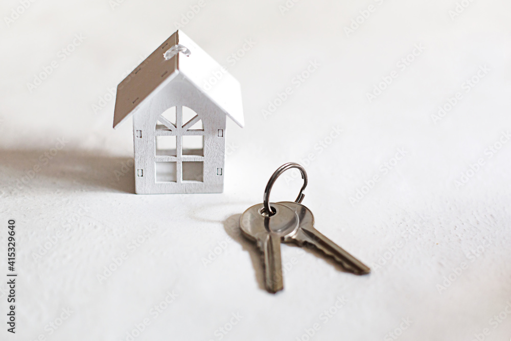 White wooden house symbol and keys on a gray background. Cottage ...