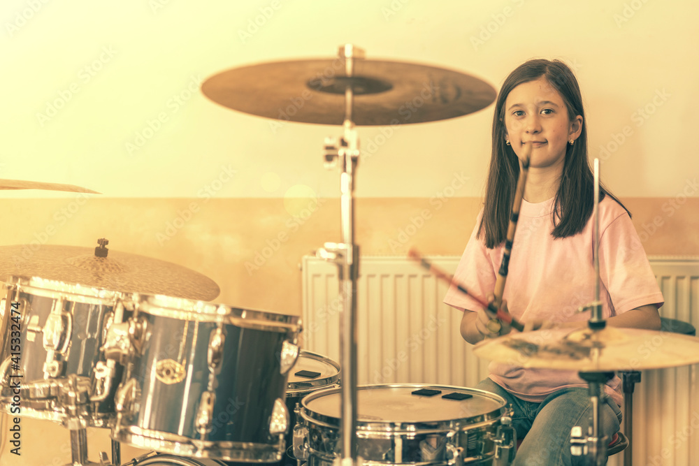 Happy girl in music therapy by playing drum kit on music room ...