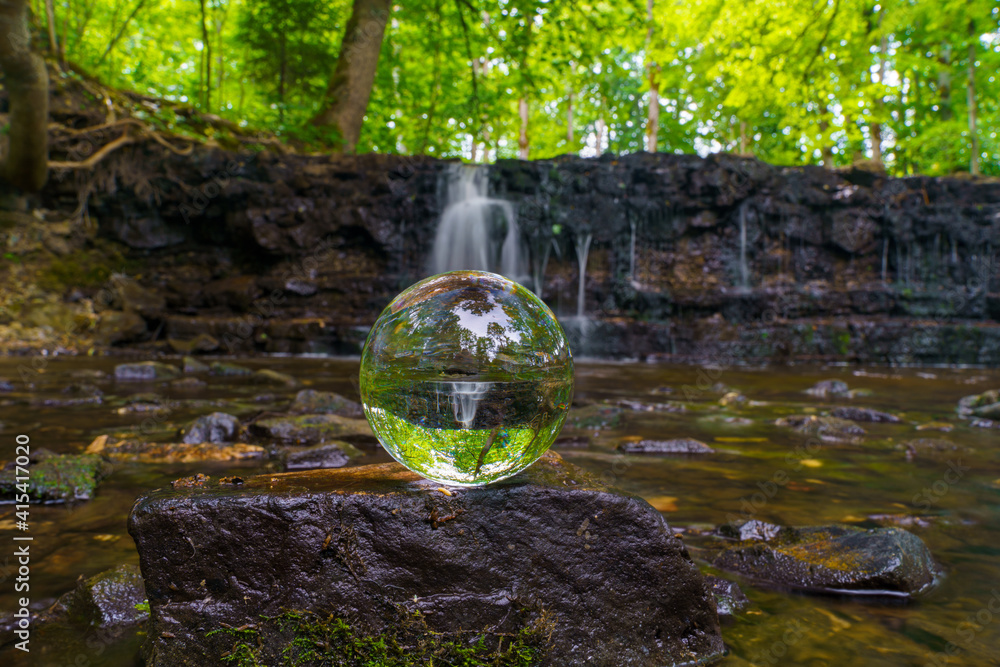 Landscape view through a glass ball showing Ivande waterfall during the ...