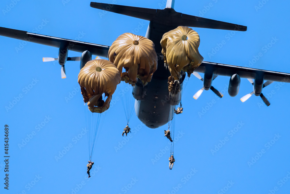 Military parachutist paratroopers parachute jumping out of a air force ...