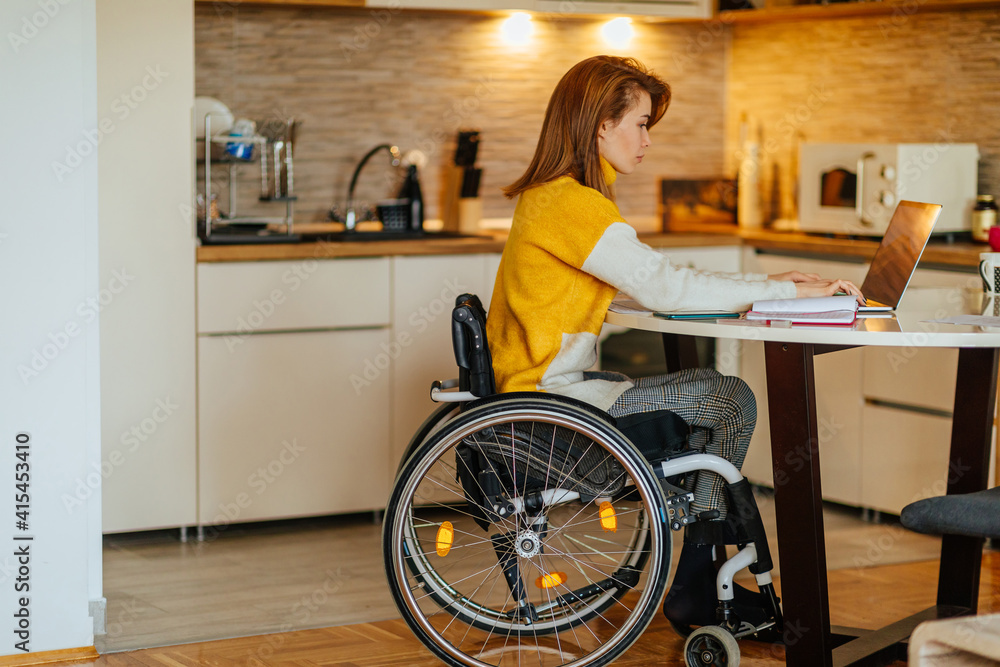 Female in wheelchair using laptop at home Stock Photo | Adobe Stock