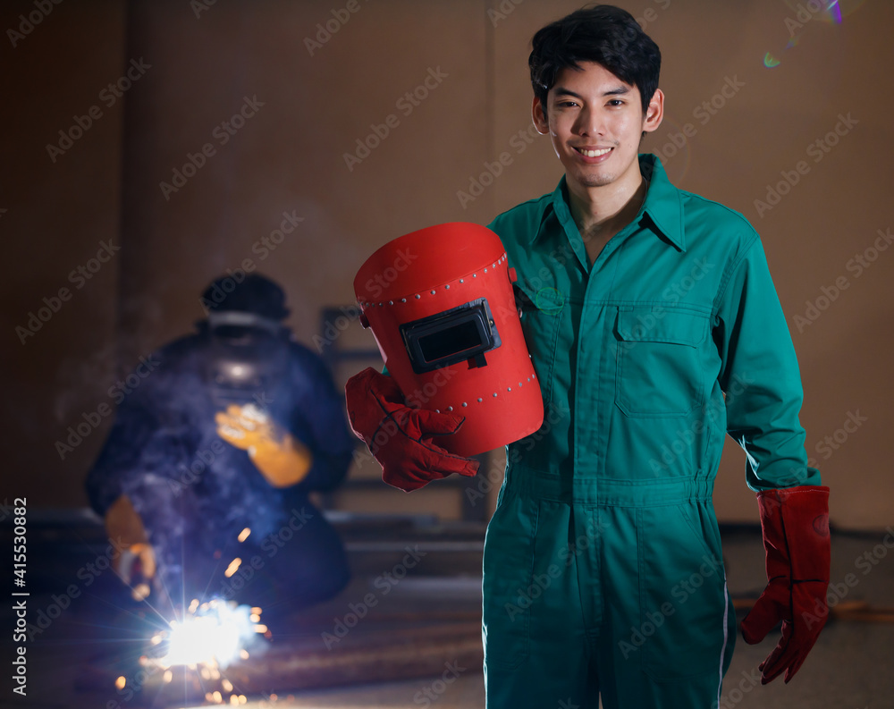 smart confident young Asian man wearing a factory uniform holding a ...