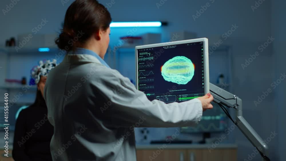 Neurologist doctor reading informations of patient looking at monitor ...