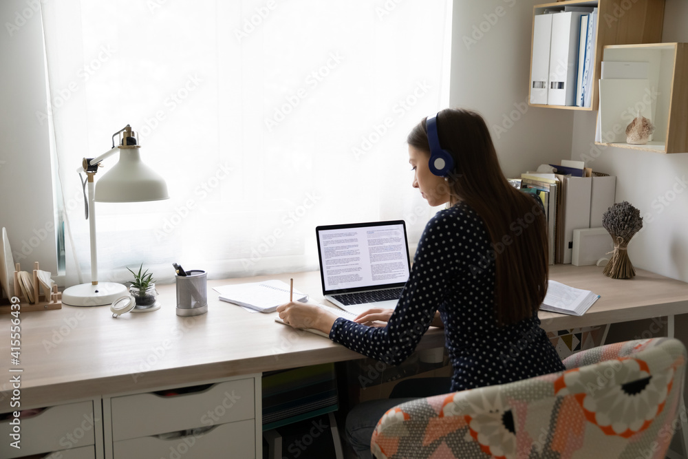 Back view of young Caucasian female student sit at desk at home study ...