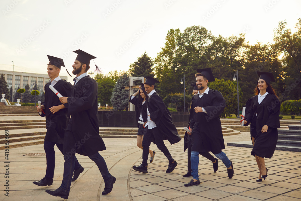 Group of young happy university graduates in traditional mantles ...