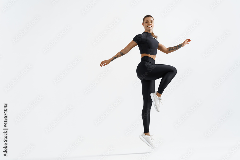 Jumping female athlete in sportswear look at empty space on white ...