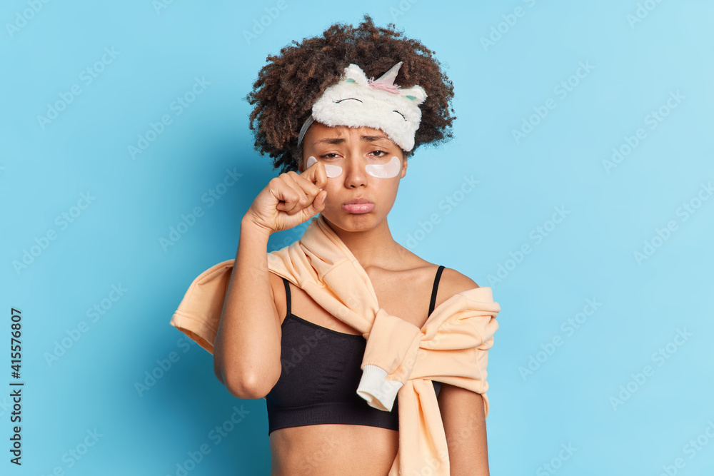 Pretty upset curly Afro American woman rubs eyes feels frustrated has ...