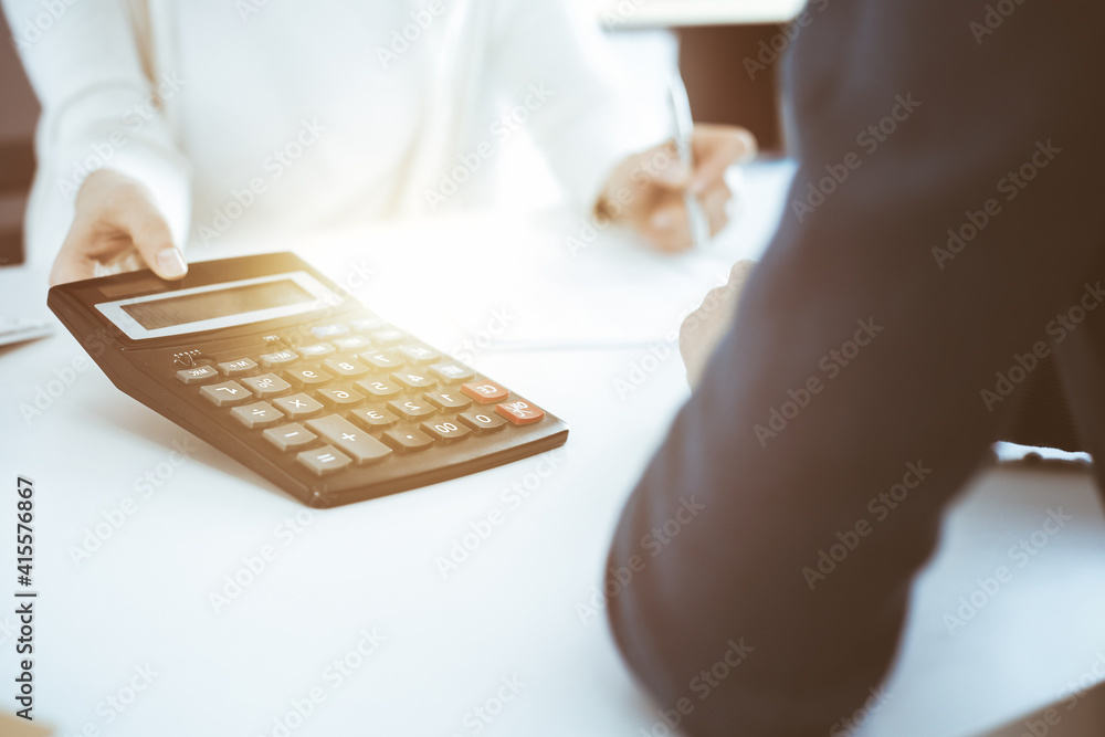 Accountant checking financial statement or counting by calculator ...