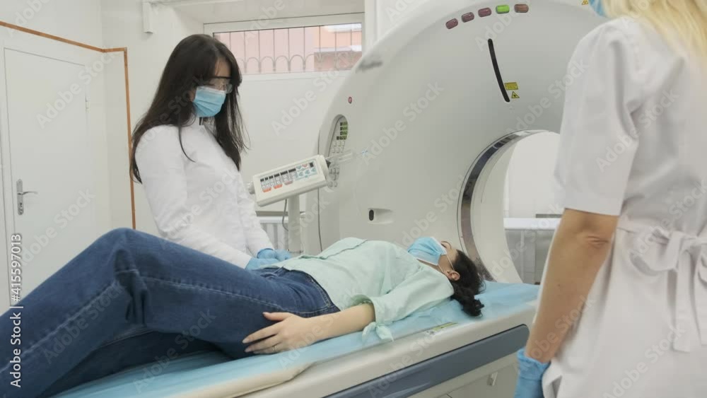 Two radiologists inserts an intravenous catheter to inject contrast to ...