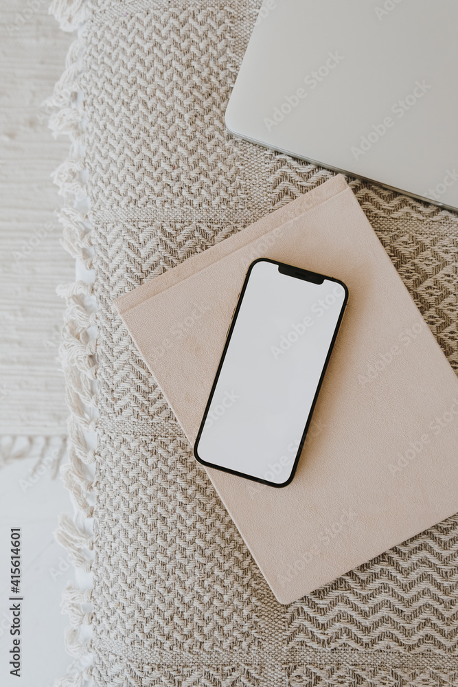 Flat lay of cellphone on blanket plaid with notebooks. Blank copy space ...