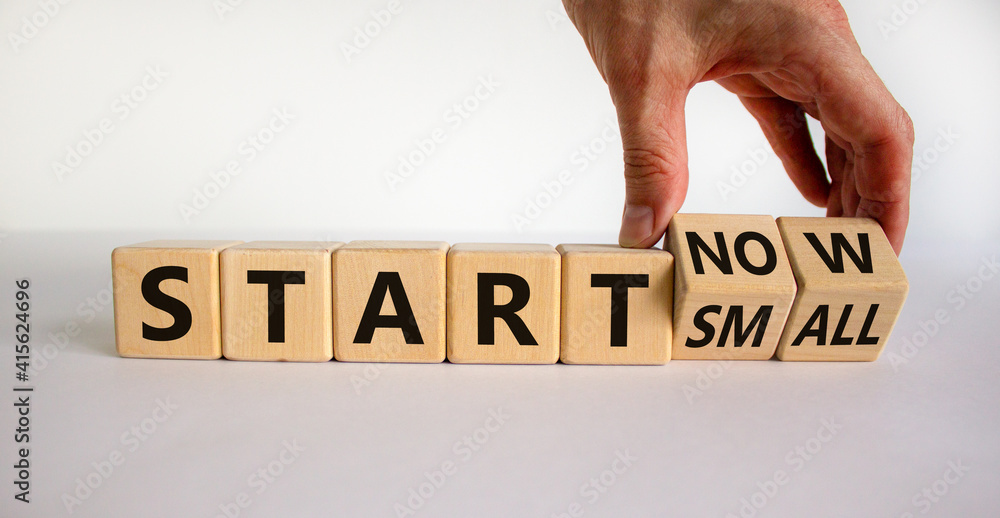 Start small and now symbol. Businessman turns wooden cubes and changes ...