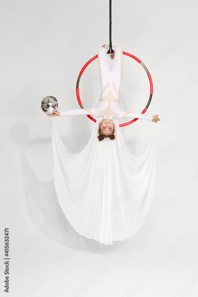 Little acrobat girl shows an acrobatic performance with mirror ball on ...