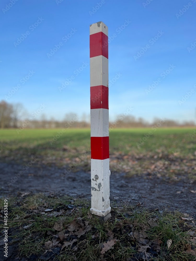 Ein in den Farben rot und weiß wechselnder Metallpfeiler bei einem ...