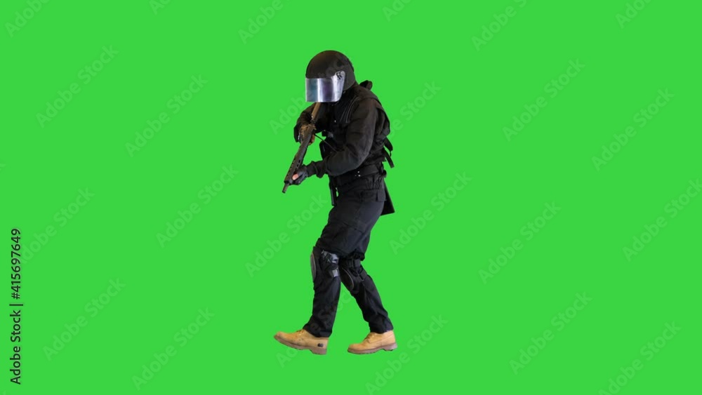 Masked Armed SWAT Police Officer Walking and aiming with rifle on a ...