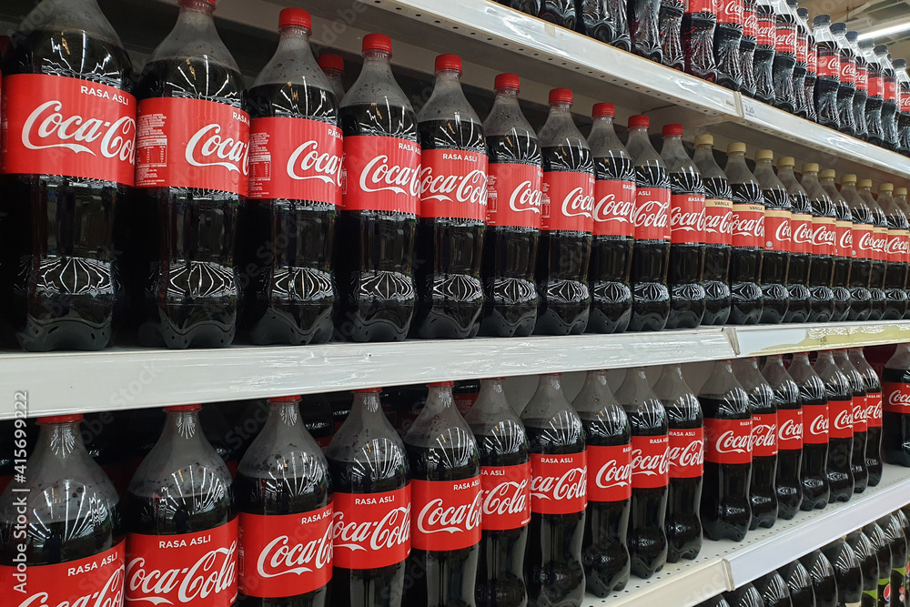 Rows of Coca-Cola bottle drink on display in a grocery store. Coca-Cola ...