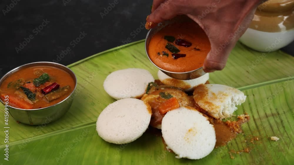Indian Man hand eating Idli idly sambar tomato coconut chutney served ...