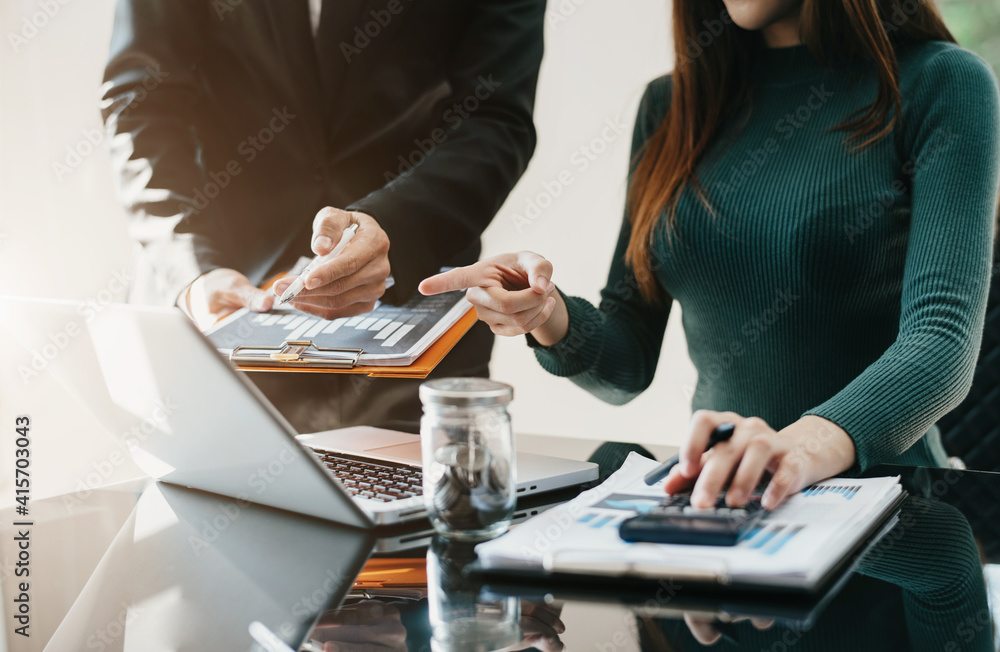 Teamwork process, Business team using a calculator to calculate the ...