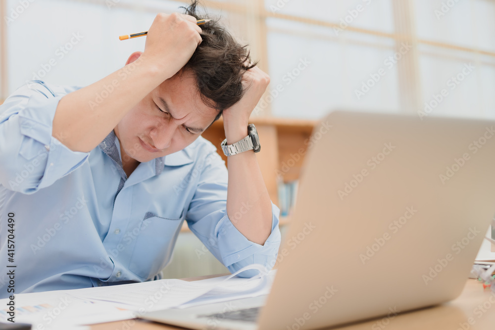 Tired businessman at workplace in office holding his headache or angry ...