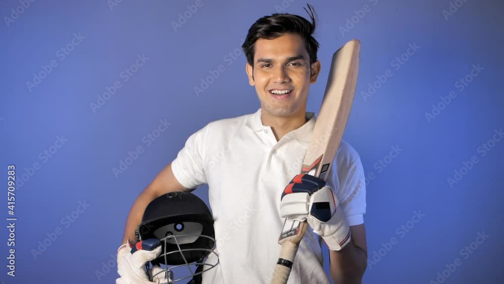 Indian cricketer in a white uniform with all cricket gears posing for ...