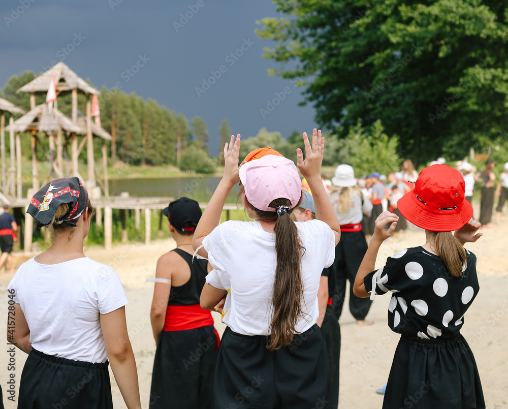 Group of girls team from back in colorful hats from the sun and ...