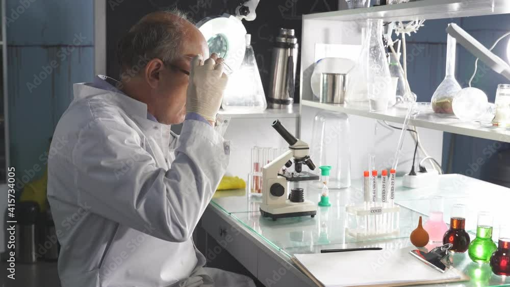 Male scientist working in modern lab, making microbiology research and ...