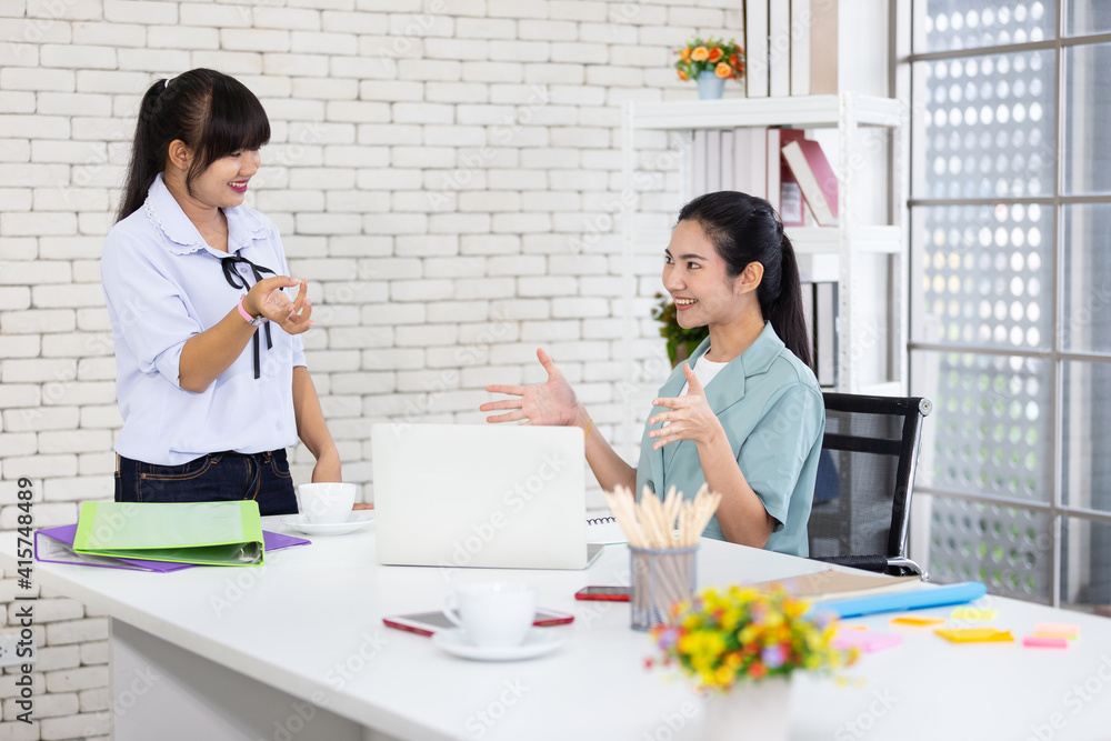 Asian women teach sign language for use in work to young girls. Using ...