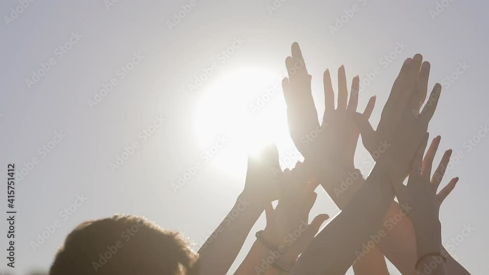Close up, people raise their hands up to the sky and join their palms ...