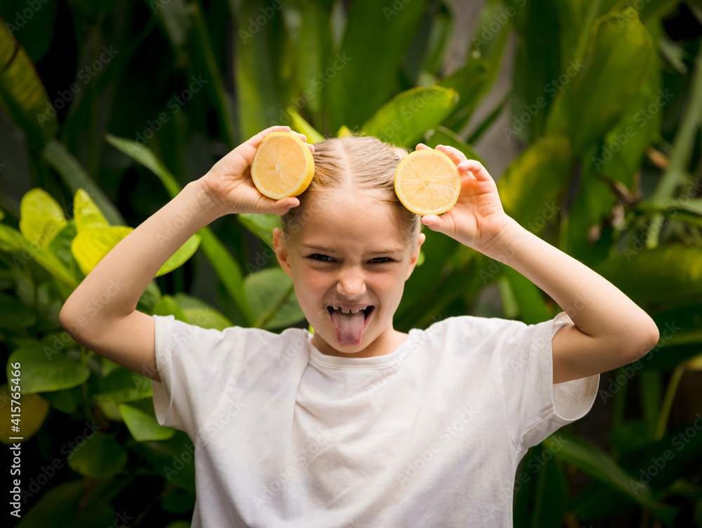 Little girl with two halves of fresh lemon. Caucasian girl holding ...