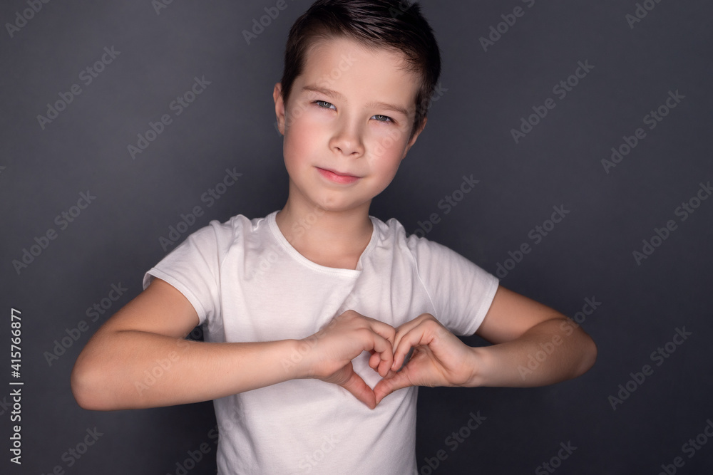 Handsome boy, cute face of a child, heart from hands, lovely model ...