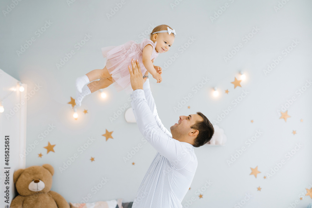 Father lifting baby girl. Happy father picks up and throws his lifting ...