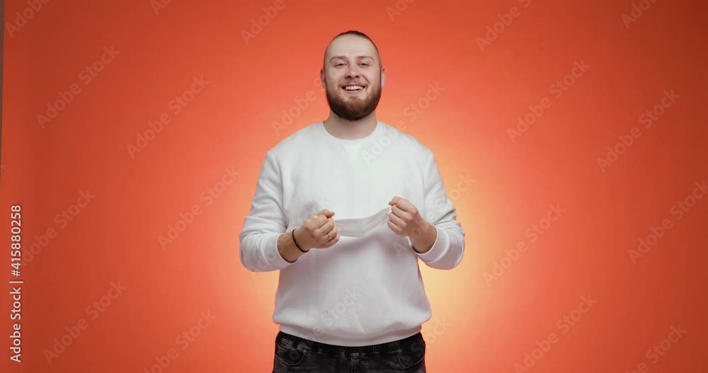 Young friendly bearded man with tail in hairs in sweater and jeans ...