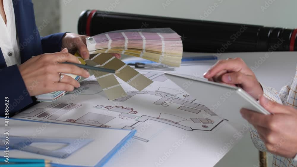 Close-up of designers hands over paper blueprint of house layout, woman ...