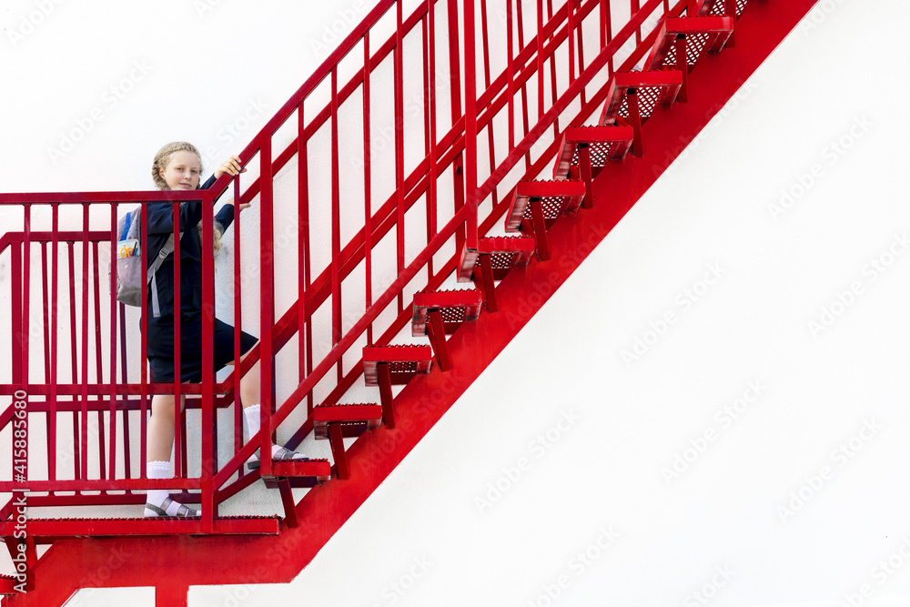 Schoolgirl climbs the stairs. stage, career ladder. girl in a uniform ...