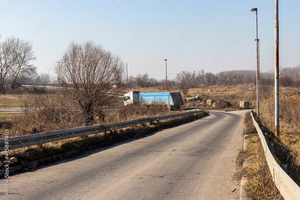 A section of road with a slope and a sharp turn, a large truck turns ...