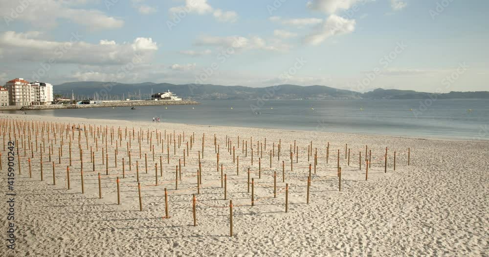 Sanxenxo Beach with areas divided with posts and rope. Social ...