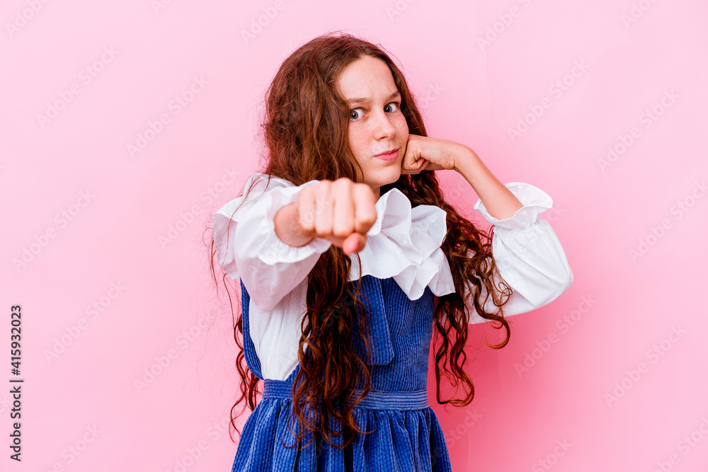 Little caucasian girl isolated on pink background throwing a punch ...