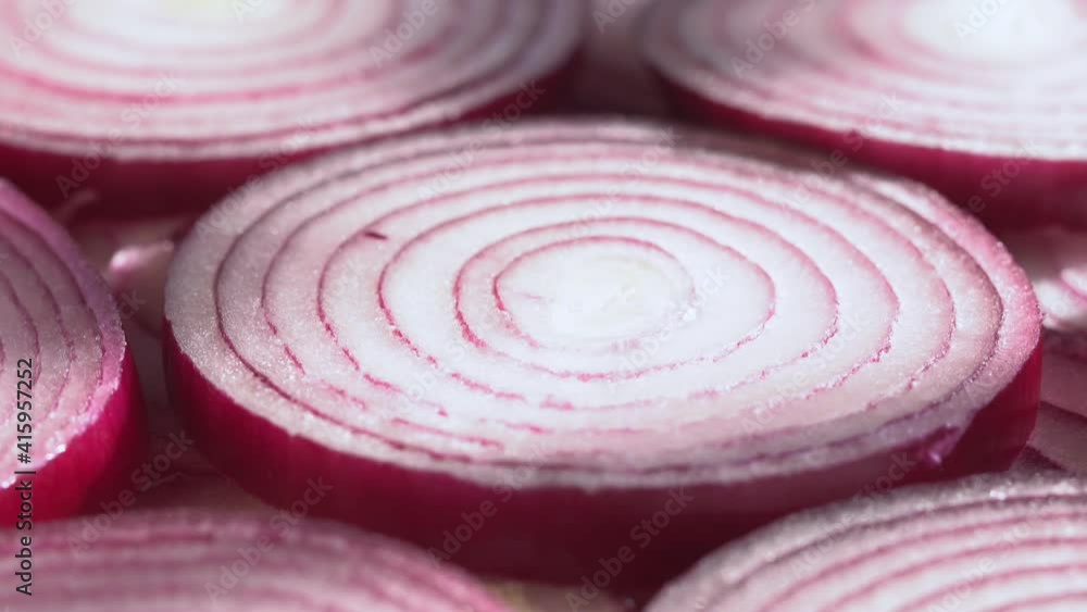 Sliced red onion rings rotating in 4K. Closeup top view of healthy food ...