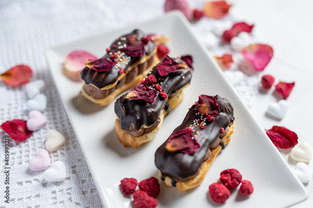 creamy chocolate eclair with edible flowers, rose petals and freeze ...