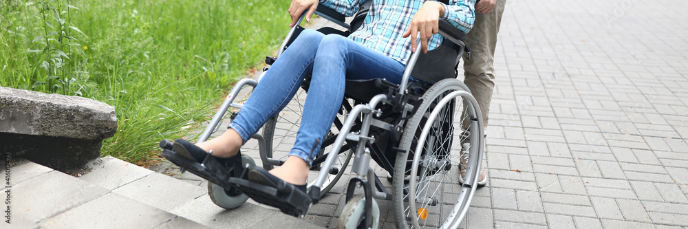 Stockfoto Man lift disabled person with stroller up stairs in city ...