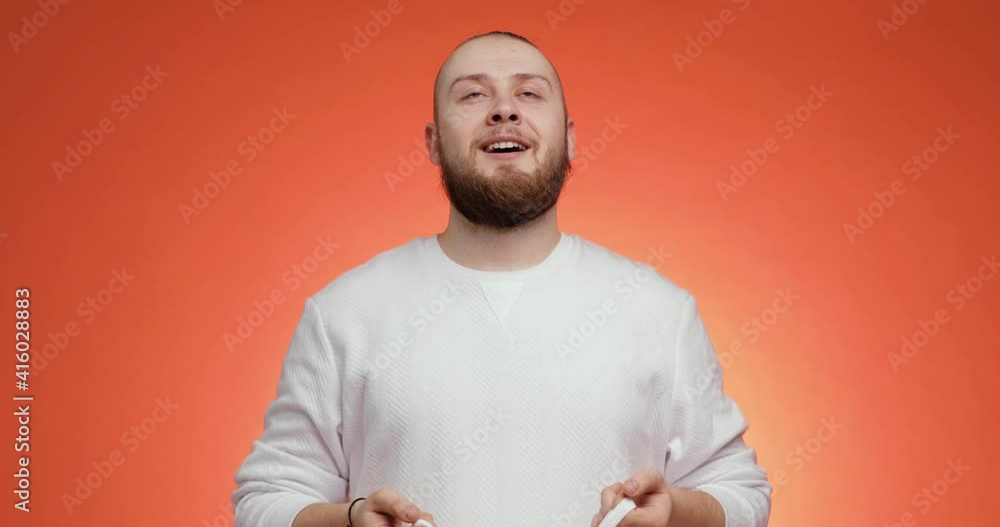 Young friendly bearded man with tail in hairs in sweater and jeans ...