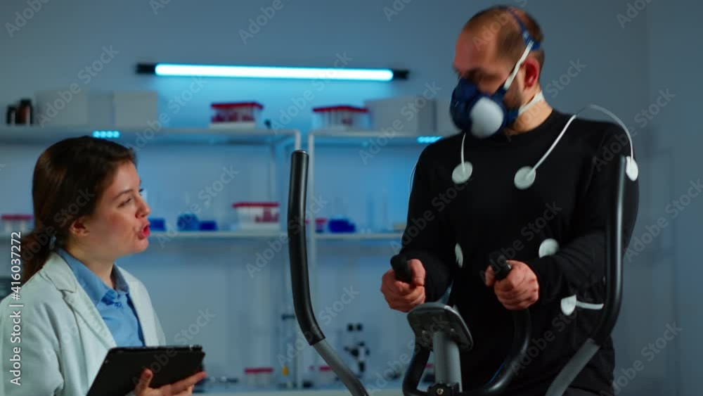 Vidéo Stock Doctor science typing on tablet while measuring sportsman ...