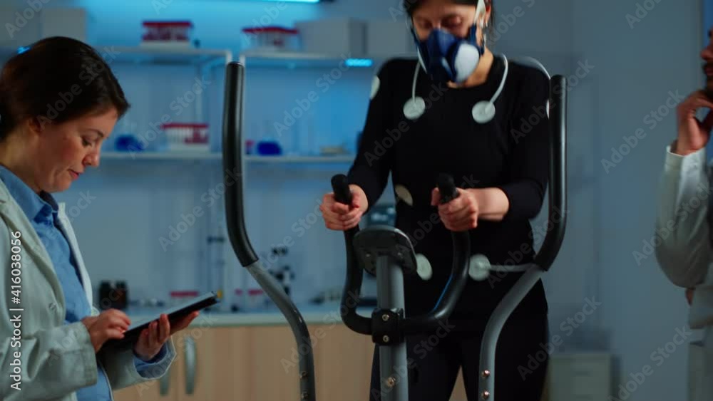 Team of doctor researchers monitoring endurance of woman performance ...