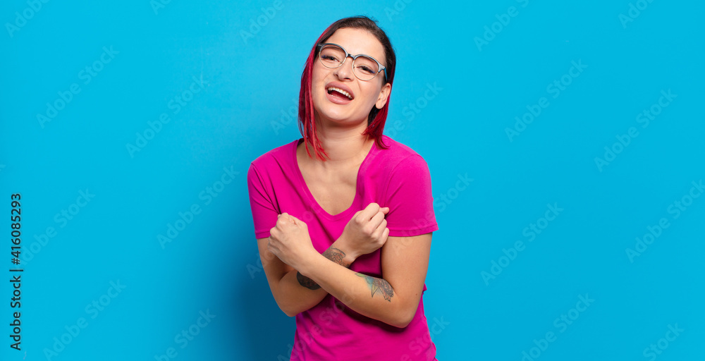 smiling cheerfully and celebrating, with fists clenched and arms ...