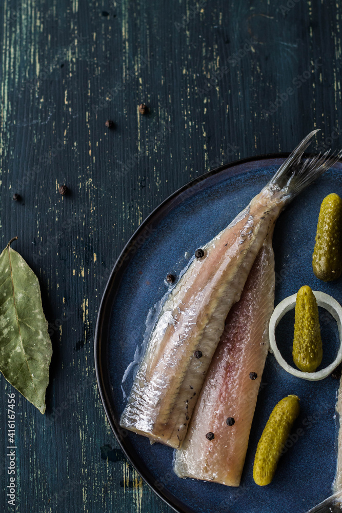 Traditional Dutch food herring fish with pickled cornichons and onion ...